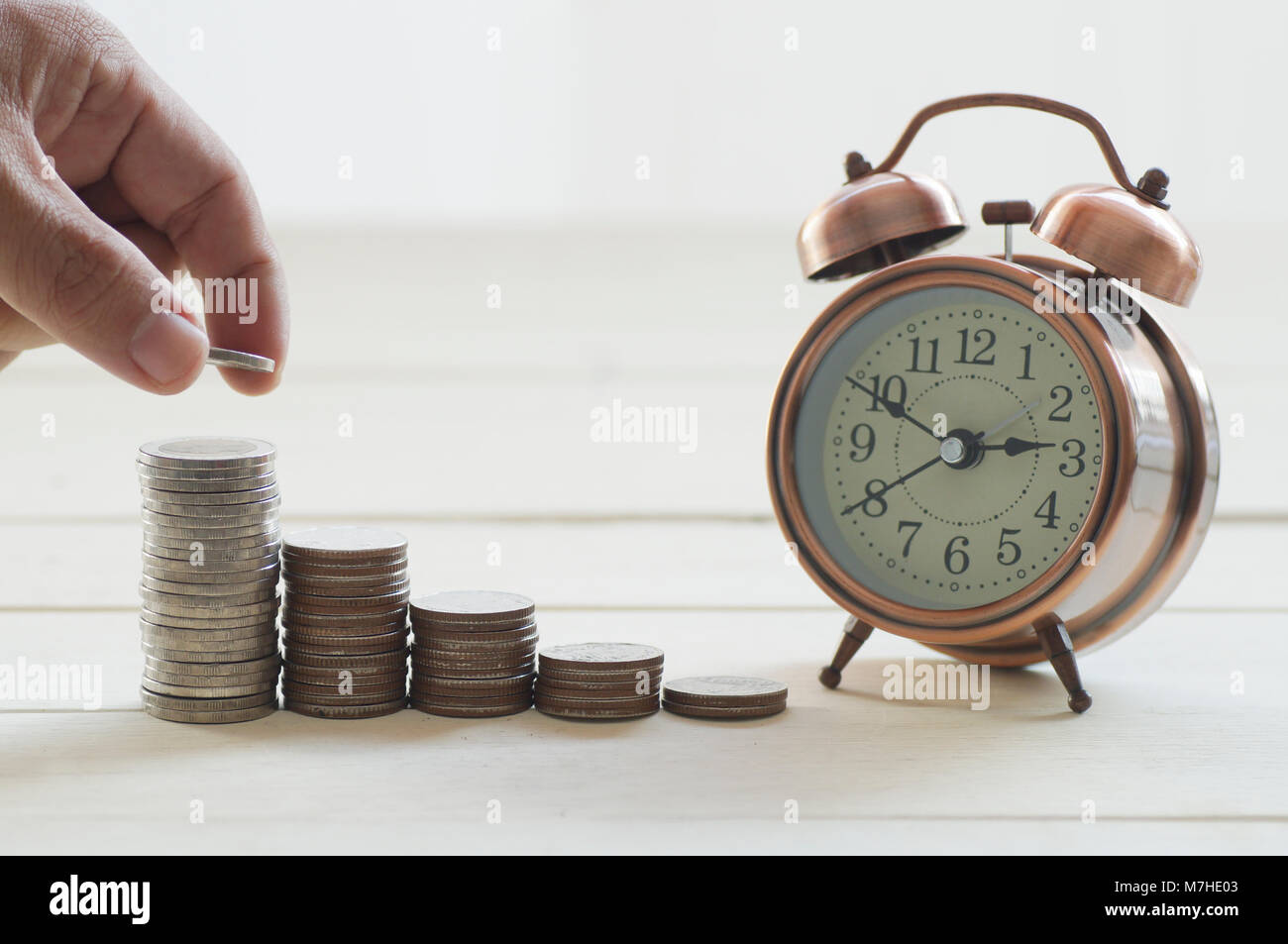 hand put money on pile of coin on table Stock Photo - Alamy