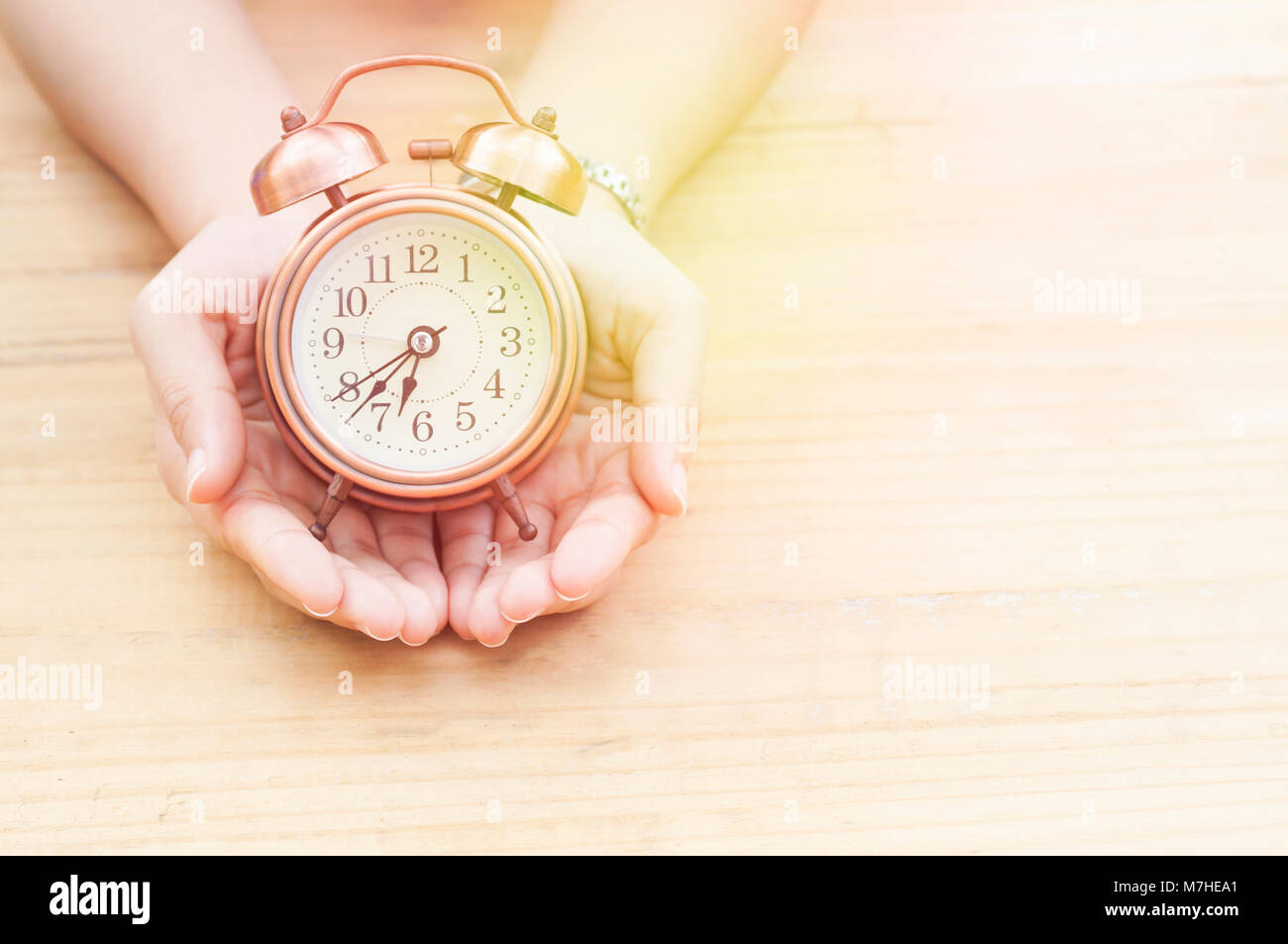 clock in hand on wood table with copy space, concept in time for life ...