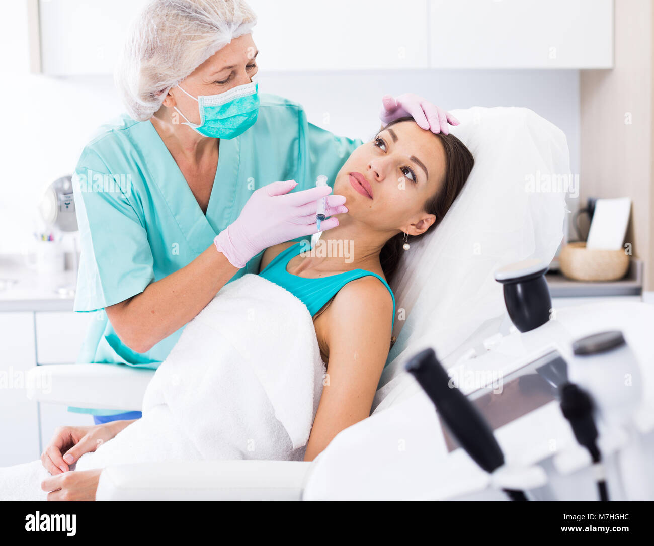 Young woman getting injection for facial correction procedure in ...