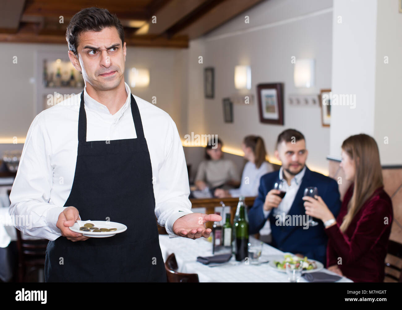 Portrait of waiter dissatisfied with small tip from cafe visitors Stock ...