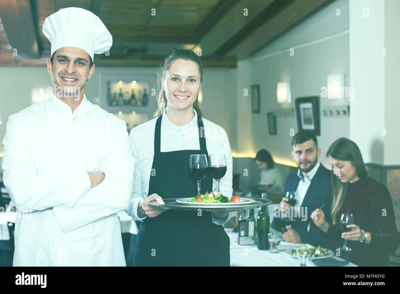 Portrait of confident male chef and smiling waitress in restaurant ...