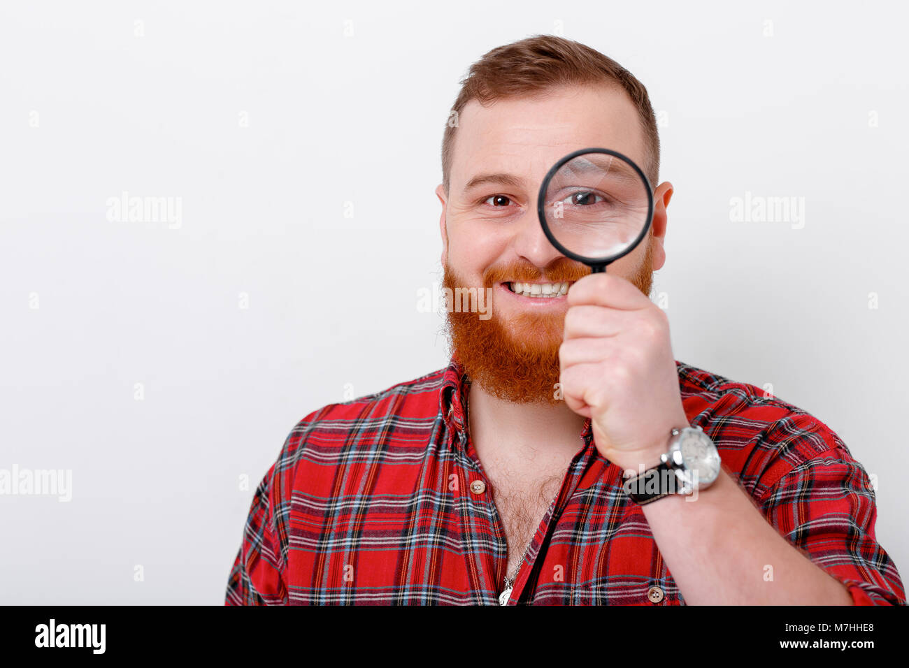 man looking at magnifying glass Stock Photo - Alamy