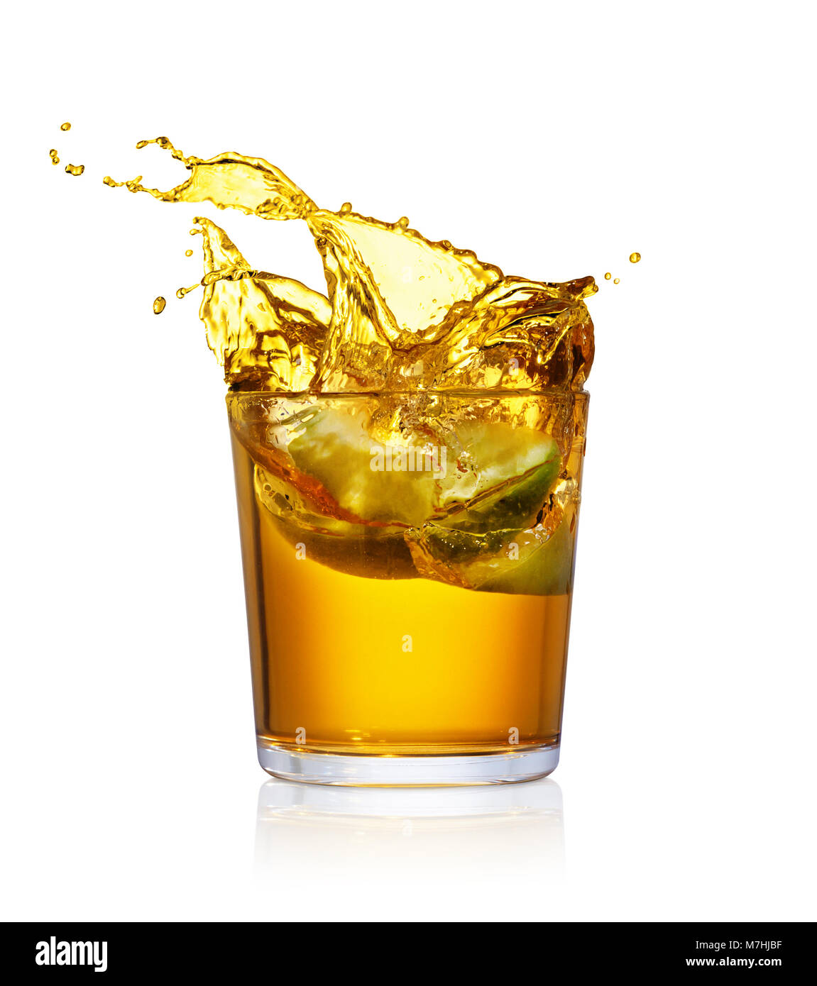 apple slice falling into juice creating splashes. Isolated on white ...