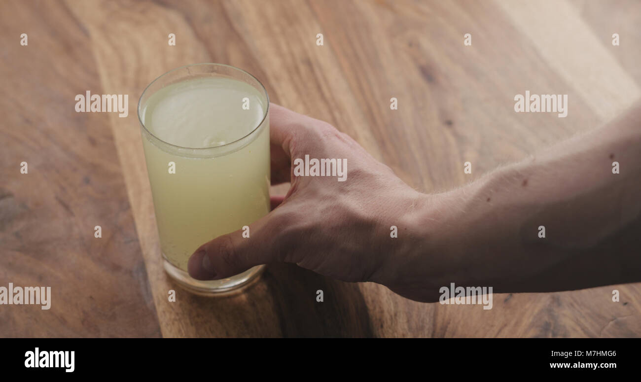 man hand take glass with vitamin drink from wood table, wide photo ...