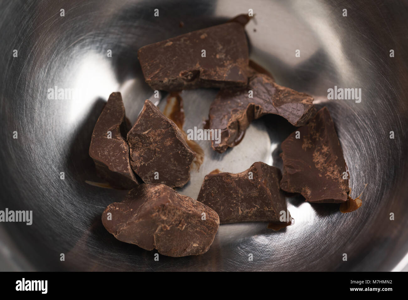 melting dark chocolate chunks in steel bowl, closeup Stock Photo - Alamy