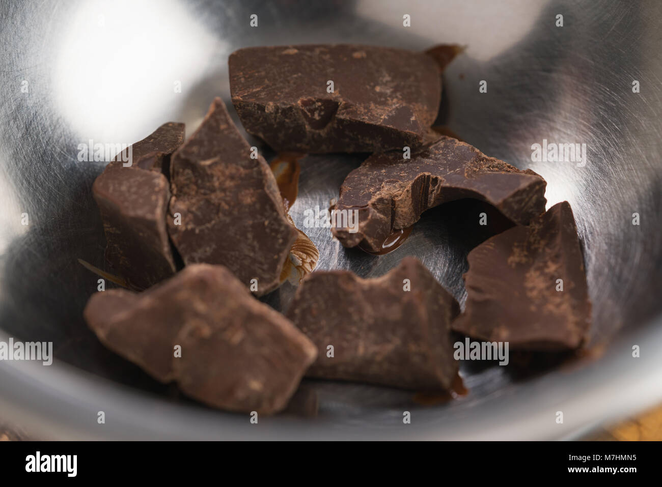 melting dark chocolate chunks in steel bowl, closeup Stock Photo - Alamy