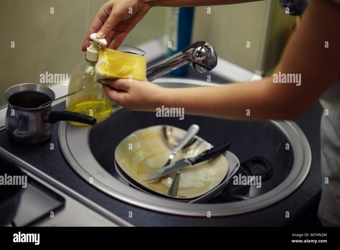 Washing frying pan in sink hi-res stock photography and images - Alamy