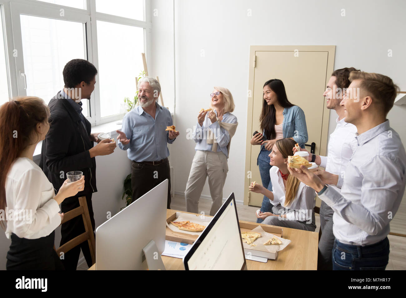 Friendly Diverse Business Team Talking And Laughing Eating Pizza Stock