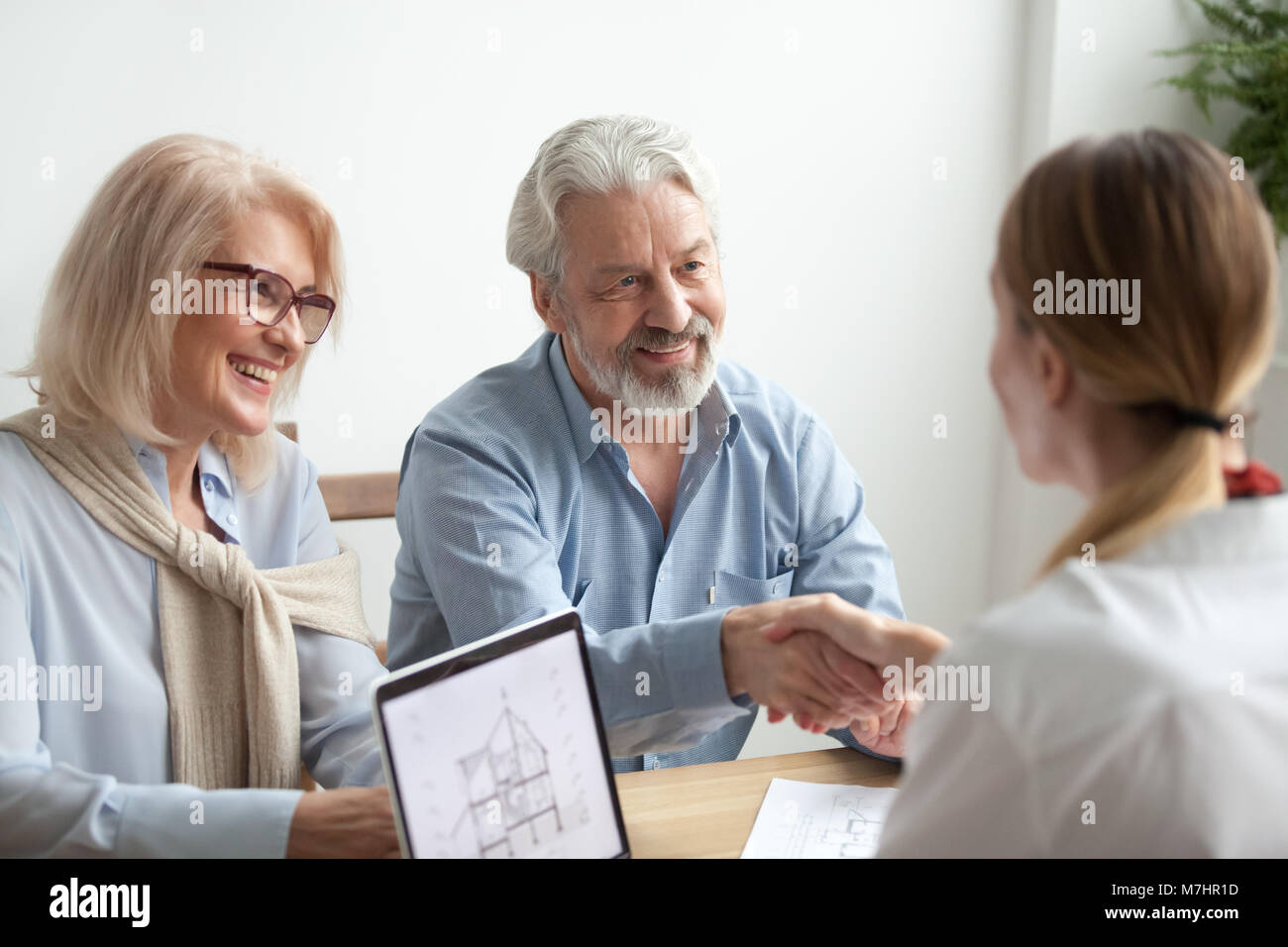 Happy older family and realtor shake hands buying new house Stock Photo ...