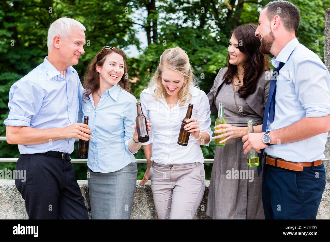 Office colleagues drinking beer after work Stock Photo - Alamy