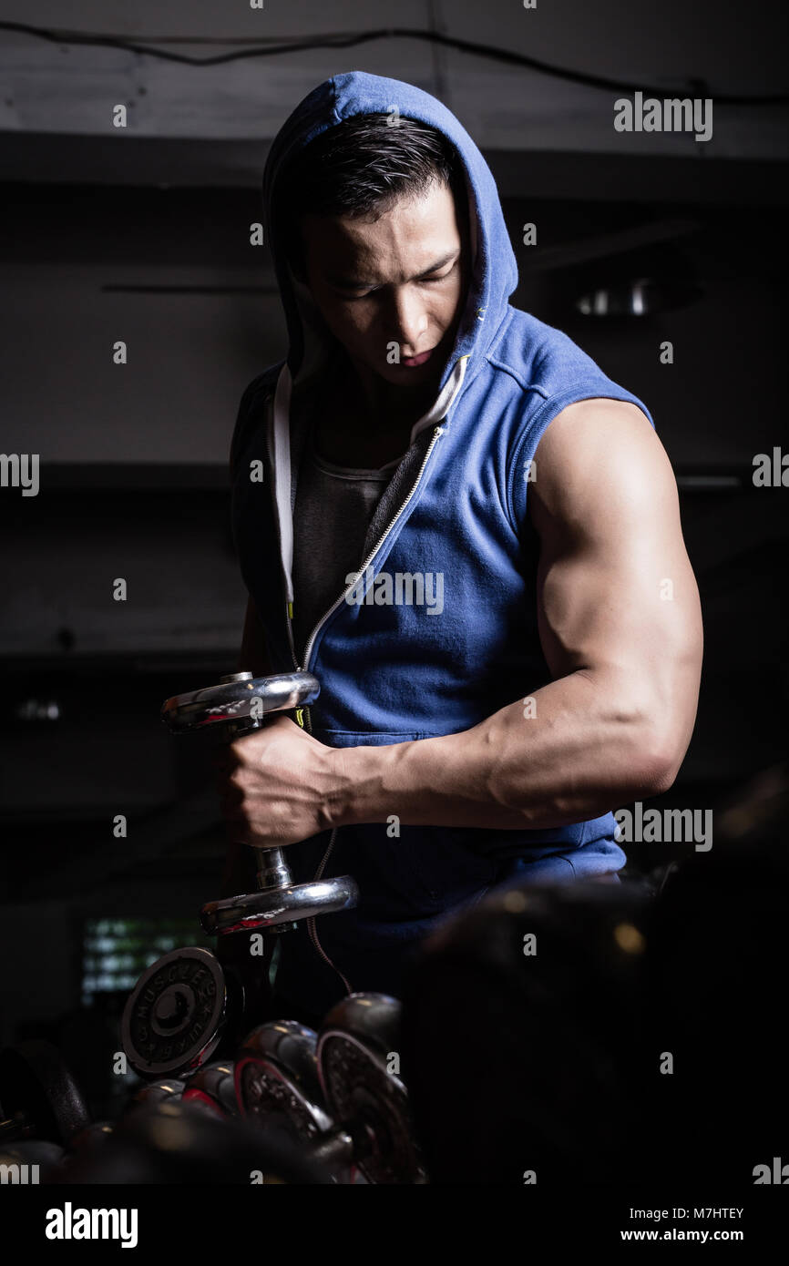 Young man reaching out with dumbbell in his hand Stock Photo - Alamy