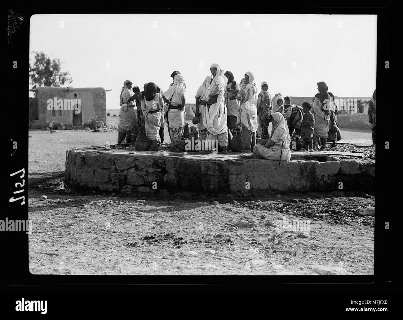 A photograph capturing crowds gathered at a village well, reflecting ...
