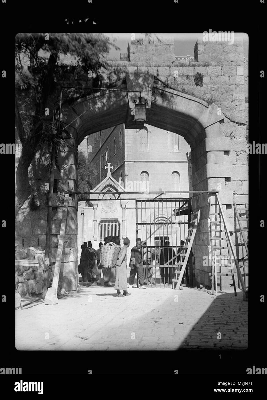 The image depicts workers installing iron gates at the New Gate on ...