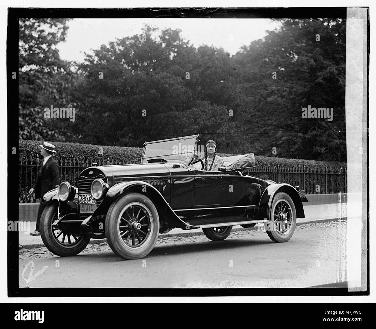 A woman dressed in Native American clothing sitting in an automobile ...