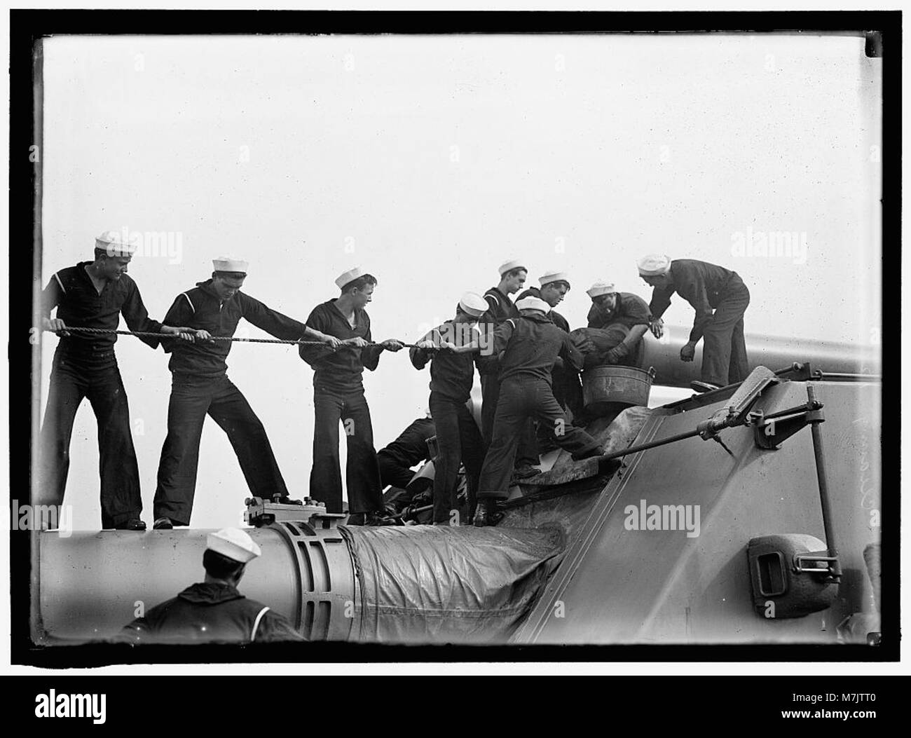 This image shows the cleaning of a 12-inch gun used for target practice ...