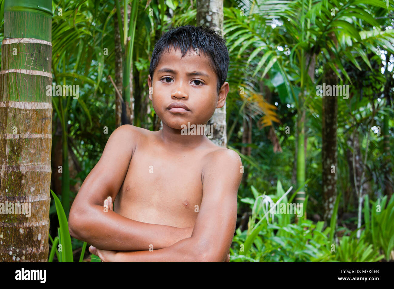 This young native boy is standing in the center of his village, Kadai ...