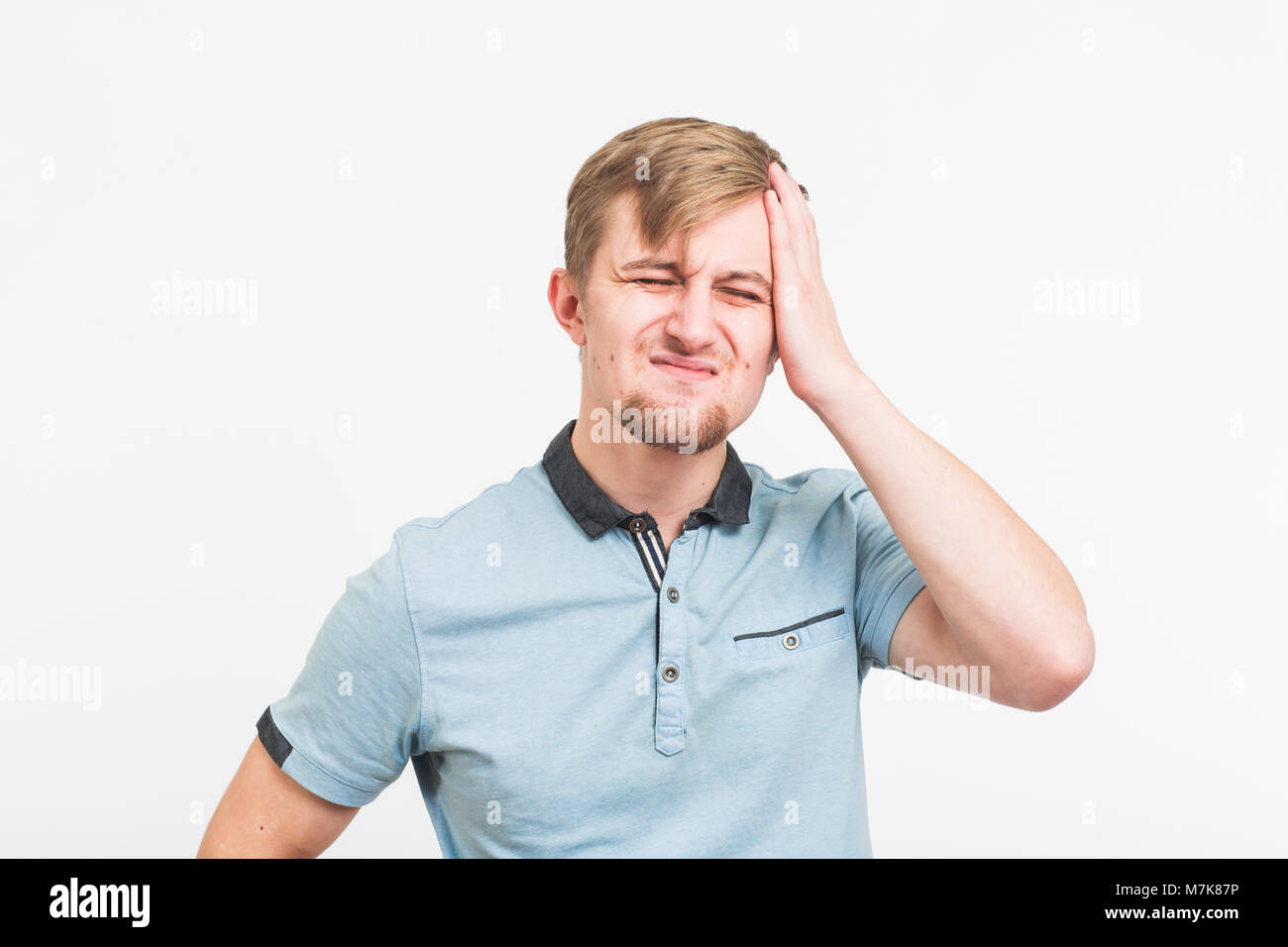 Stressed Young Man Clutching the Head in white background Stock Photo ...