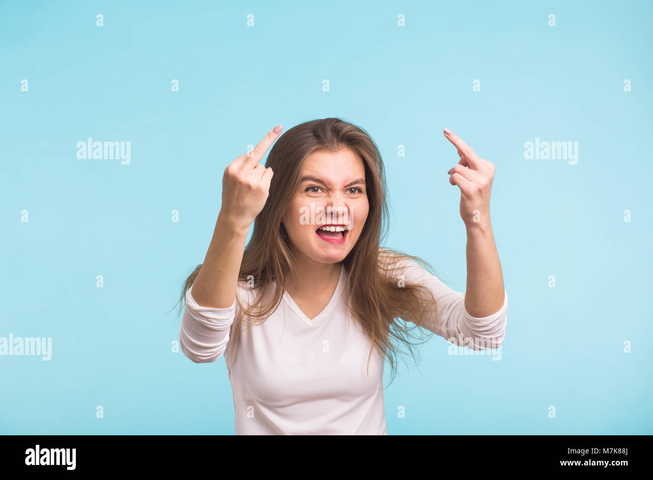 Angry aggressive woman with ferocious expression on blue background ...