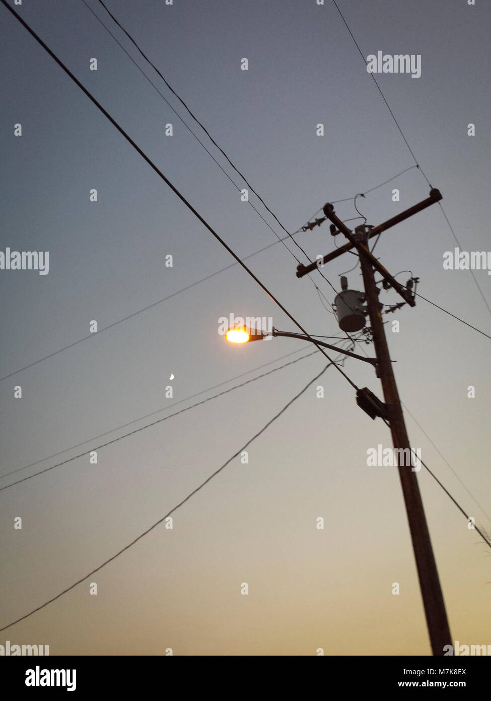 Silhouette of electricity pole, power lines and streetlamp under the ...