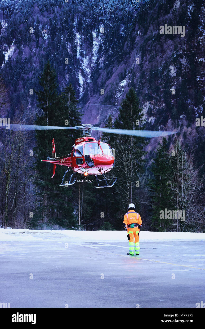 Gsteigwiler, Switzerland - December 31, 2013: Red helicopter and pilot ...