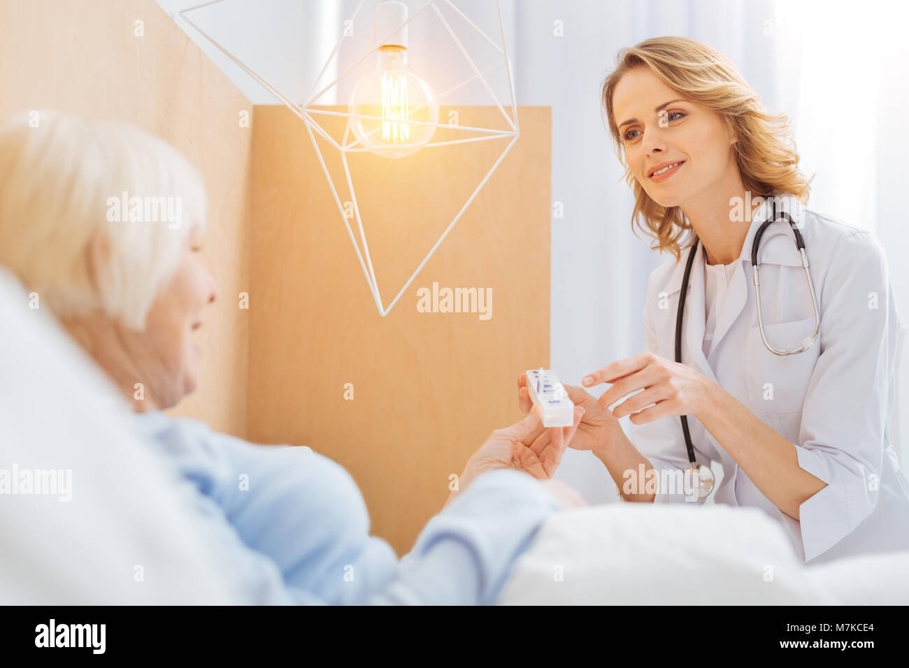 Young skilled doctor smiling to her patient Stock Photo - Alamy