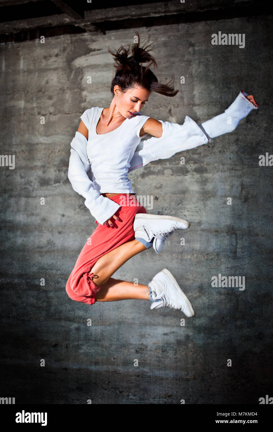 Dancing woman with brown long hair and happy facial expression jumping ...