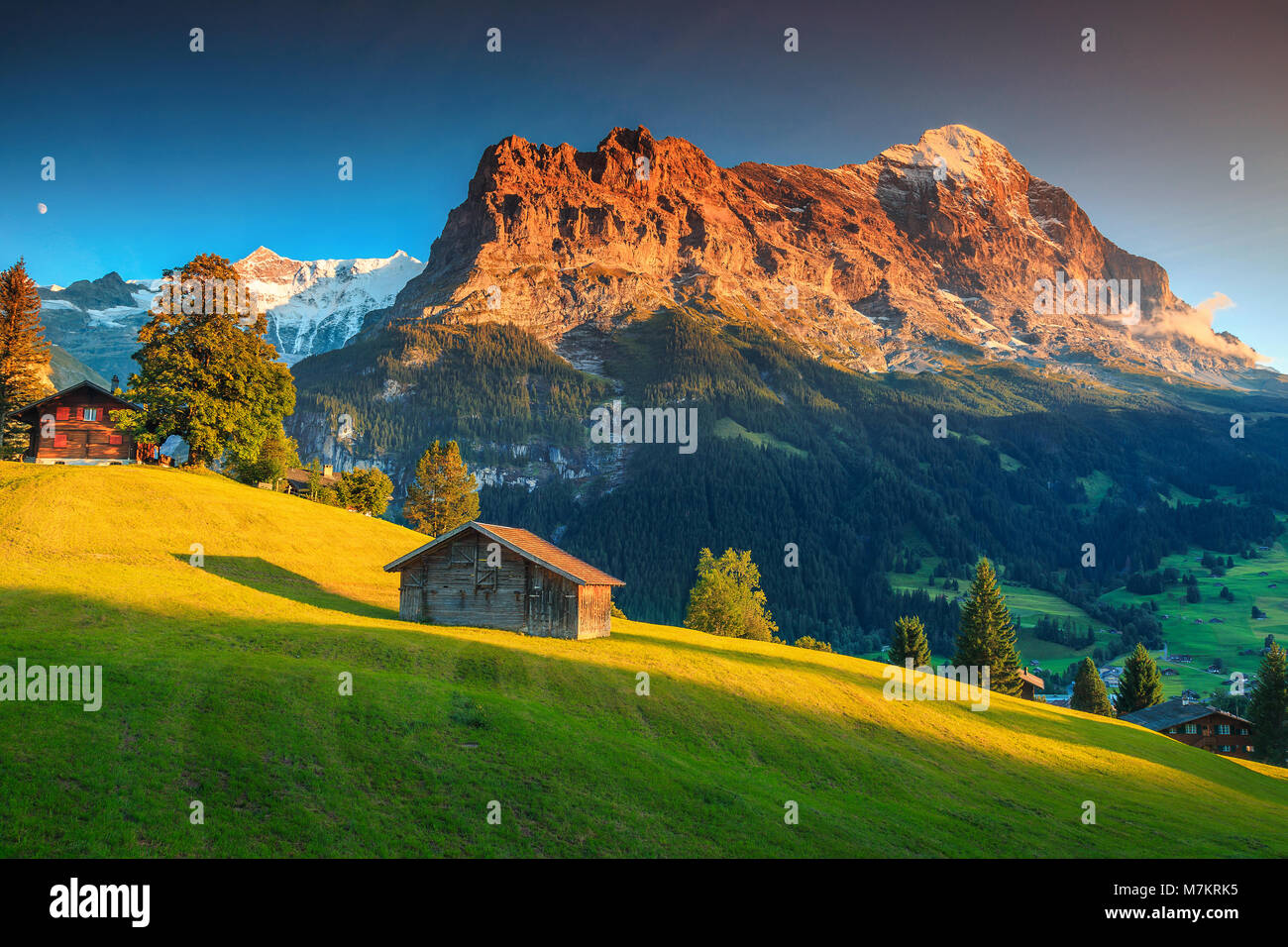 Amazing Swiss alpine mountain landscape, wooden chalets on green fields ...