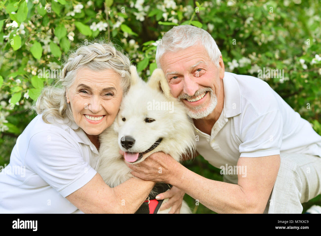 Happy couple hugging dog Stock Photo - Alamy