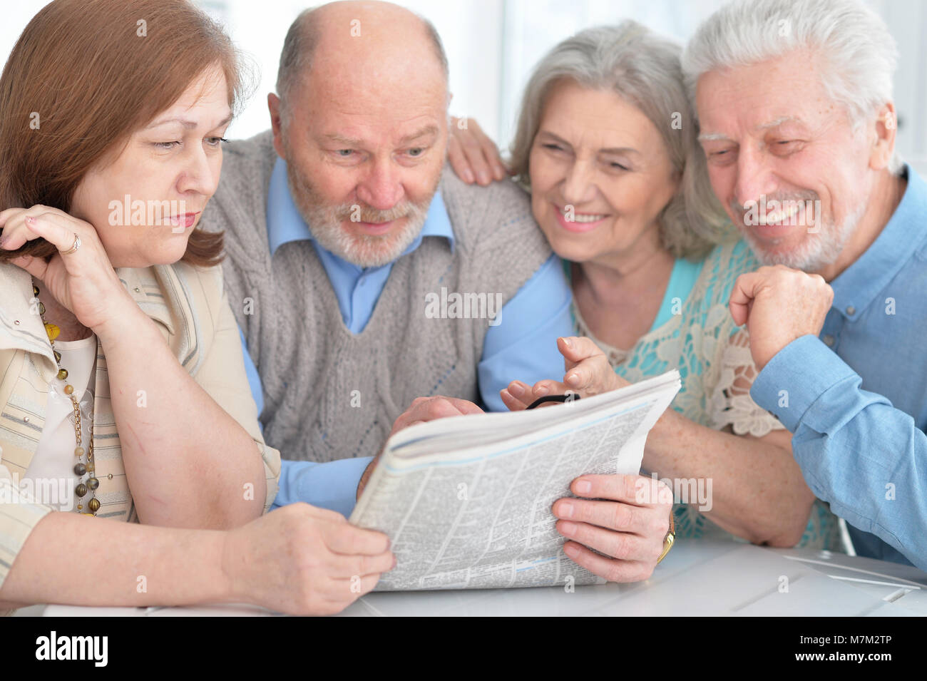 two senior couples reading newspaper Stock Photo - Alamy