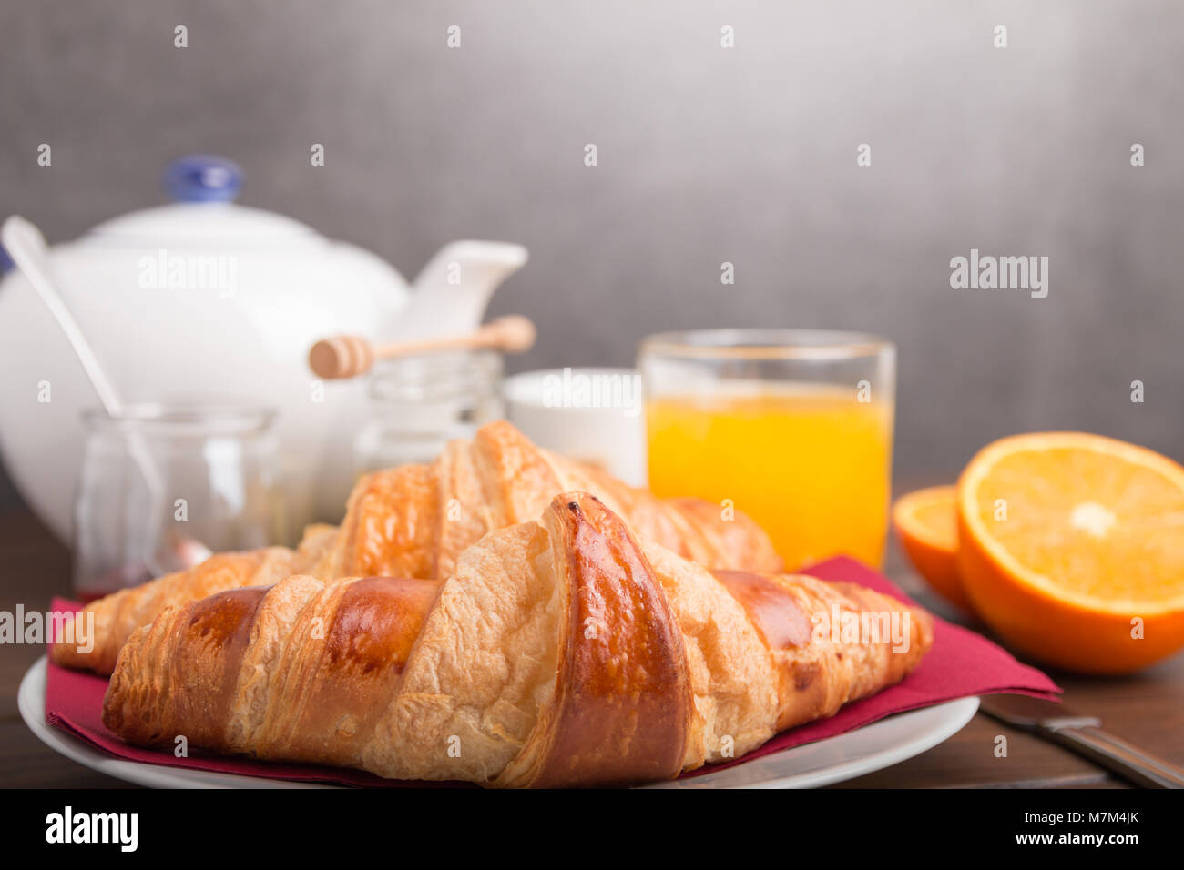 Homemade croissants on a breakfast table with fresh fruit juice and ...