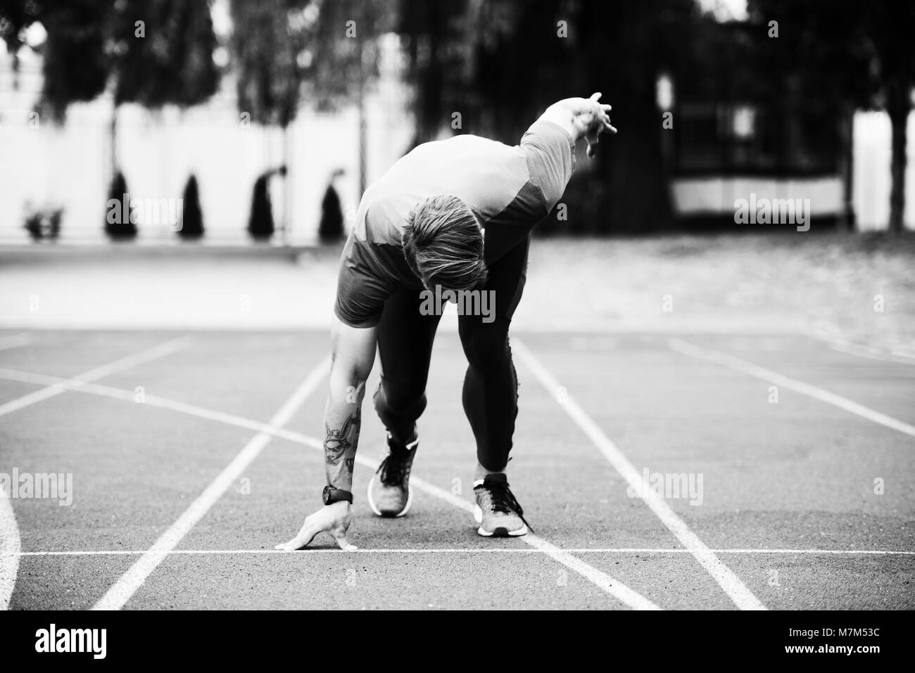 Athletic Man on Running Track Getting Ready to Start Run Stock Photo ...