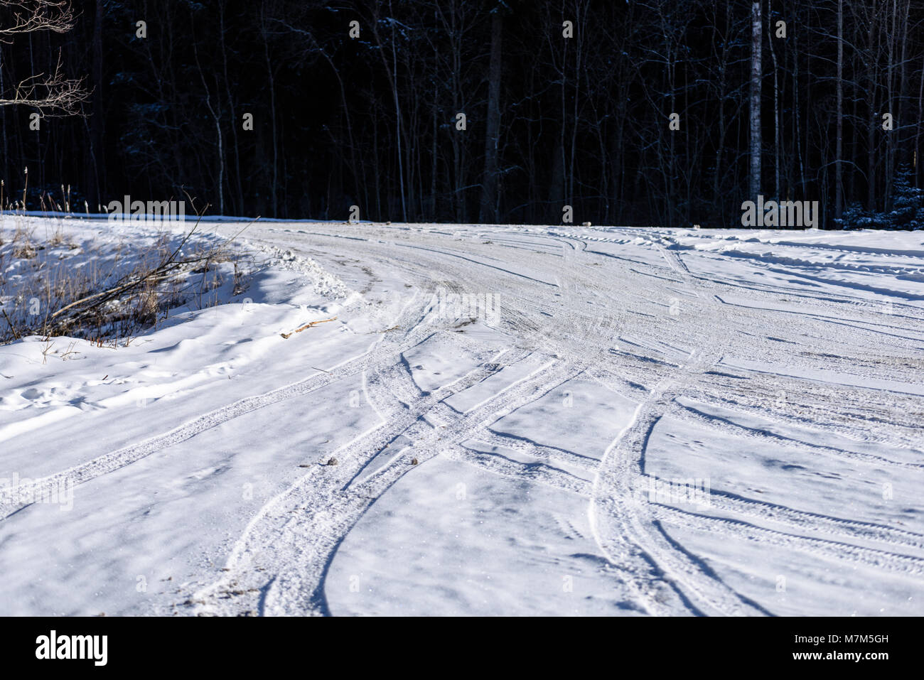 snowy winter road covered in deep snow with car tire tracks going in ...