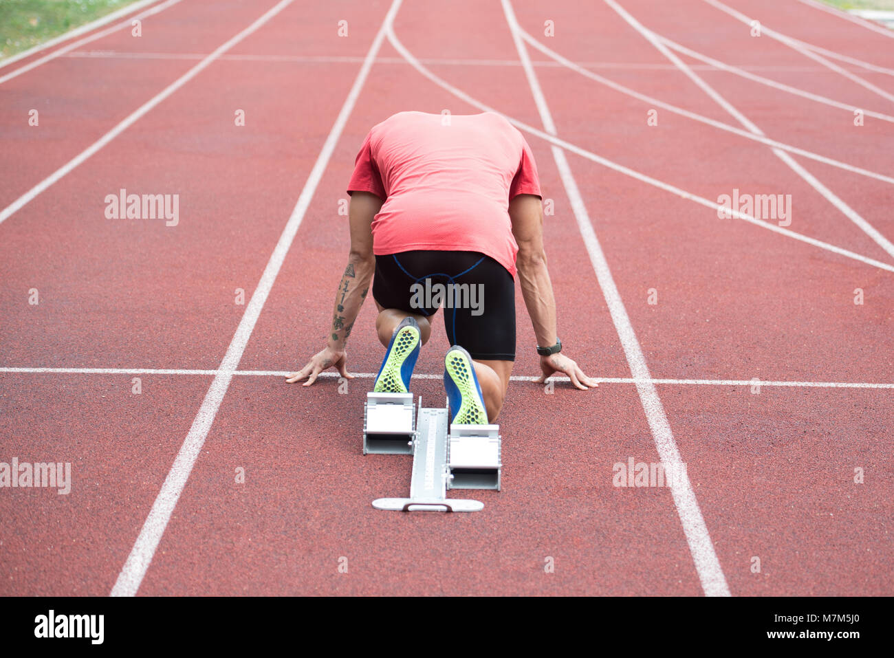 Athletic Man on Running Track Getting Ready to Start Run Stock Photo ...