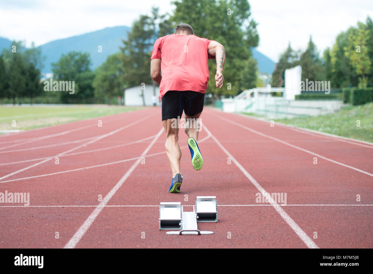 Sprinter Man Running on Red Tracks Lanes in Track and Field Stadium in ...