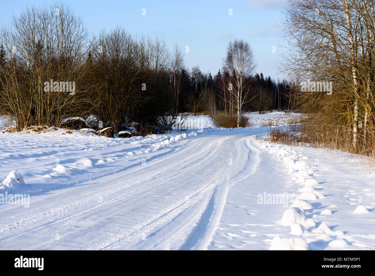 snowy winter road covered in deep snow with car tire tracks going in ...