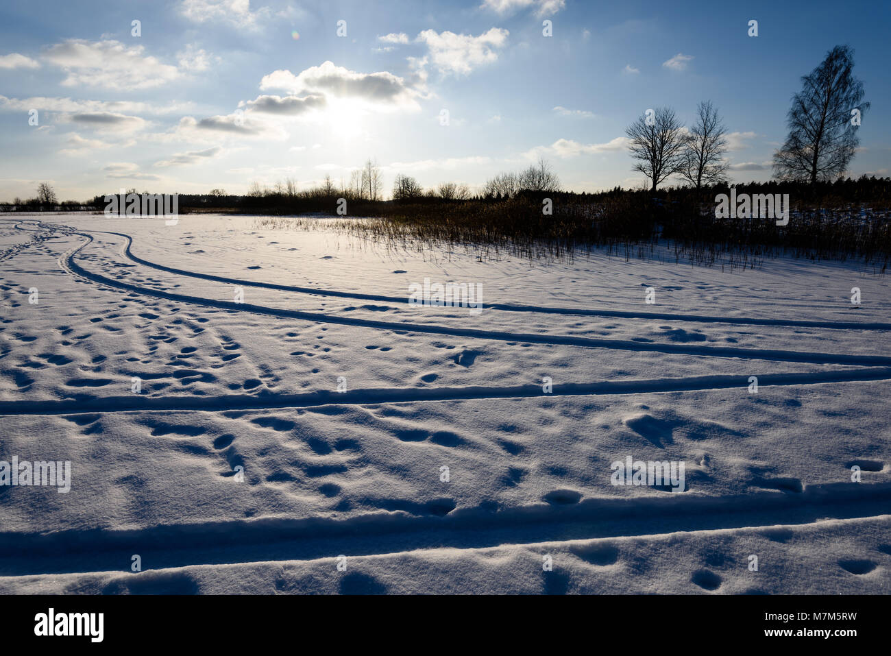 snowy winter road covered in deep snow with car tire tracks going in ...