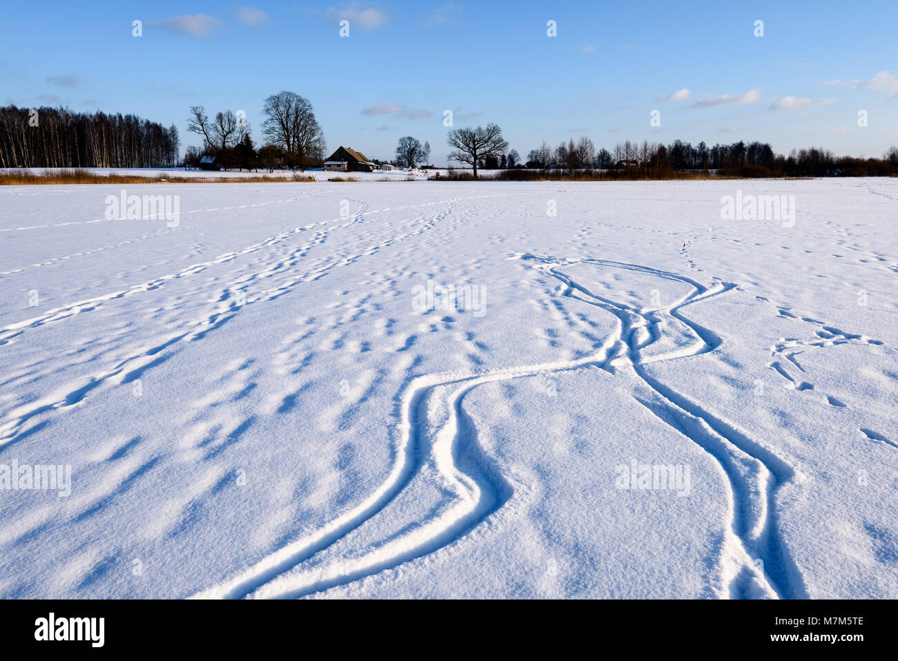 snowy winter road covered in deep snow with car tire tracks going in ...