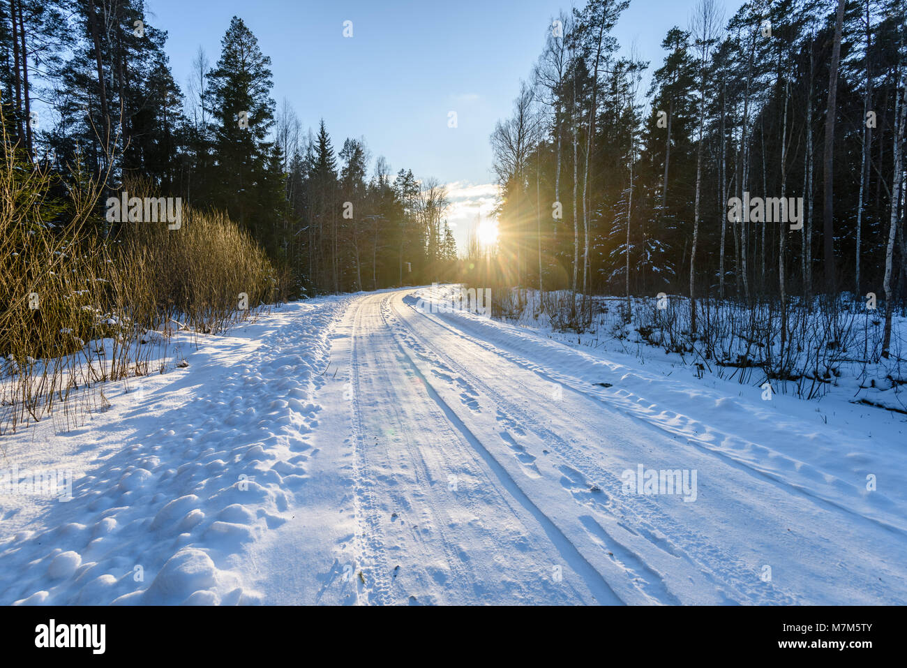snowy winter road covered in deep snow with car tire tracks going in ...