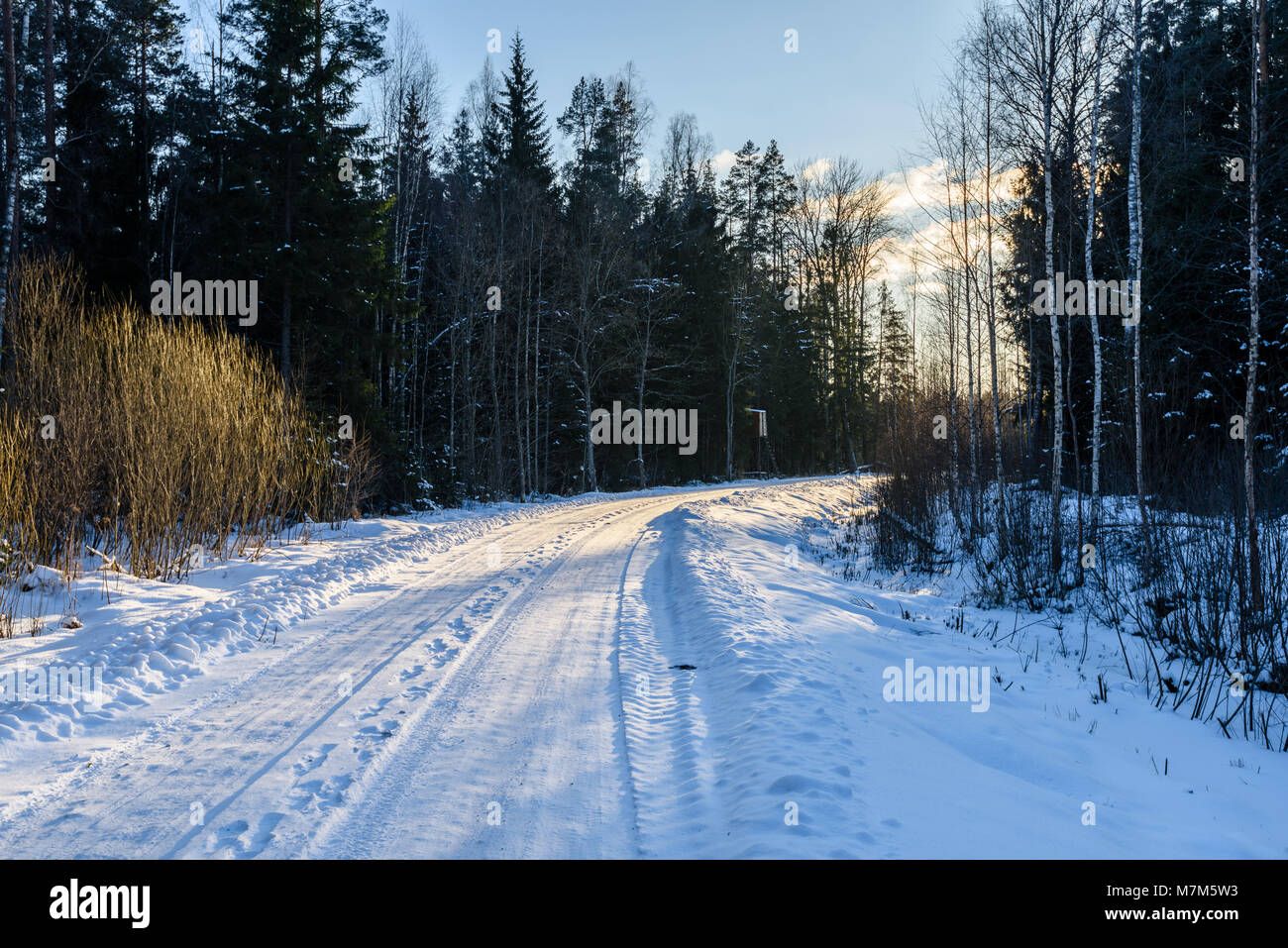 snowy winter road covered in deep snow with car tire tracks going in ...