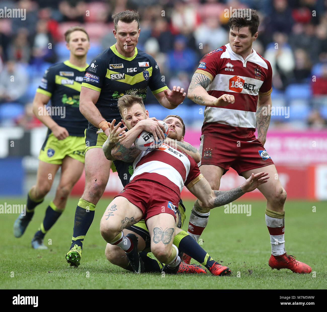 Wigan Warriors Sam Tomkins is tackled by Wakefield Trinity's Tom ...