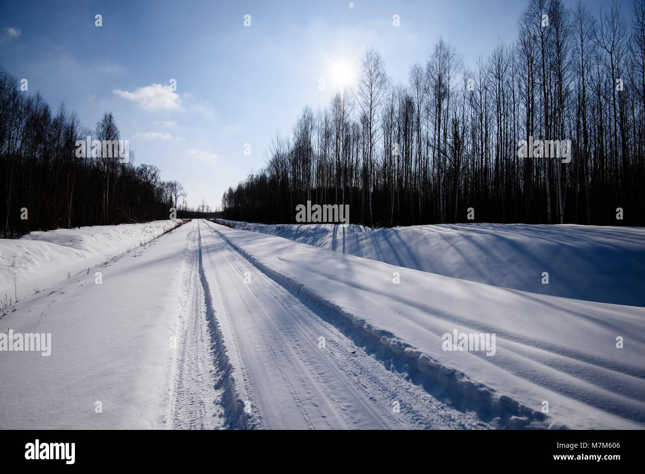 snowy winter road covered in deep snow with car tire tracks going in ...