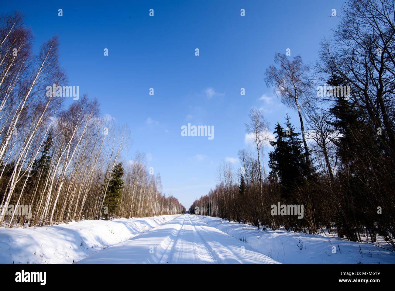 snowy winter road covered in deep snow with car tire tracks going in ...