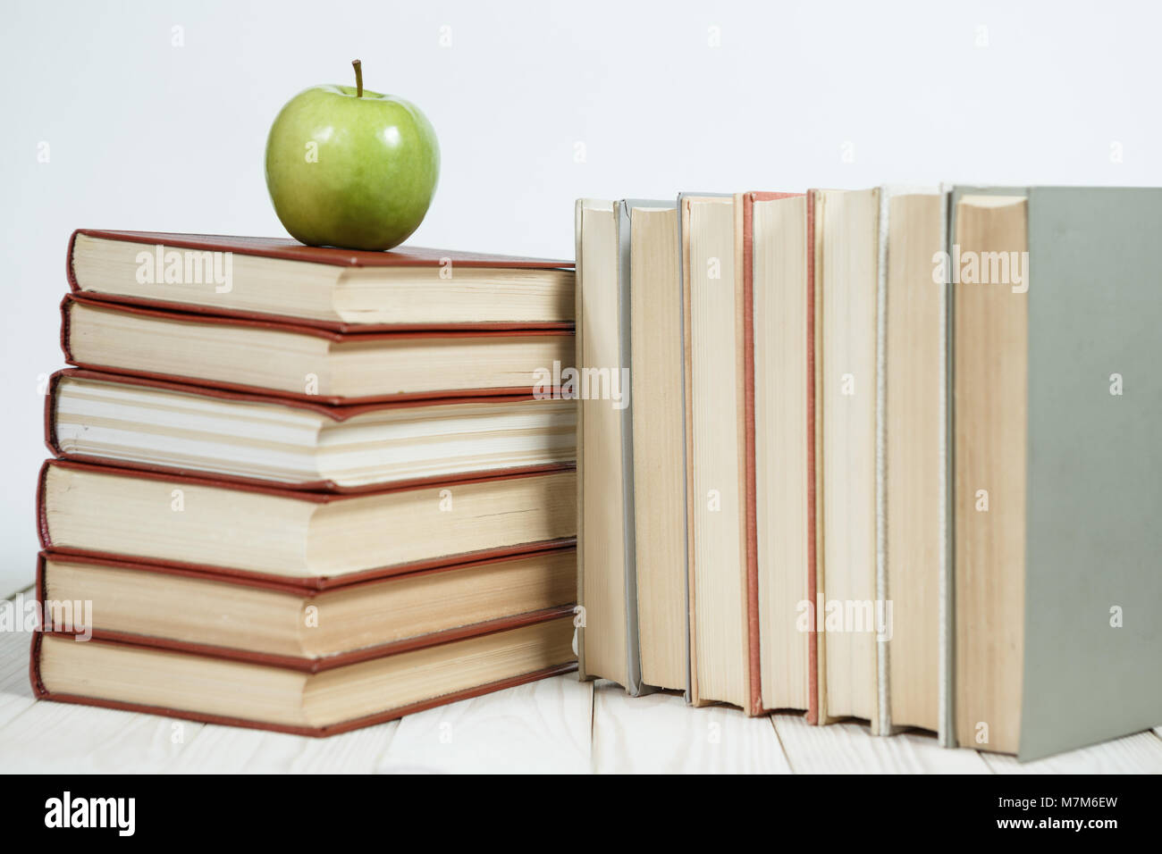 Stack of books and apple on the table Stock Photo - Alamy