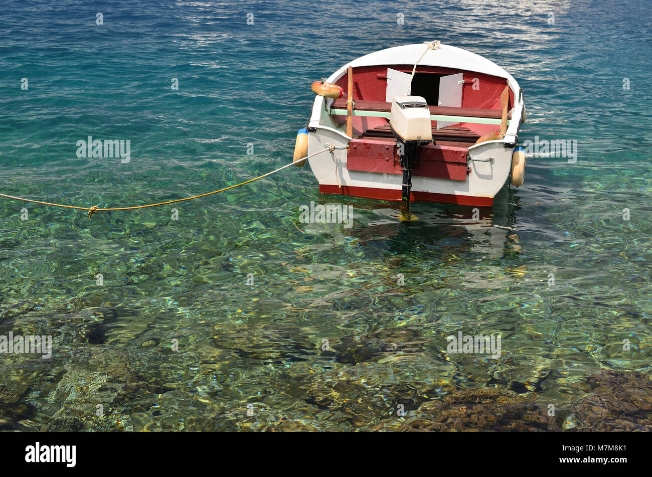 Fishing boat on a calm blue-green sea water Stock Photo - Alamy