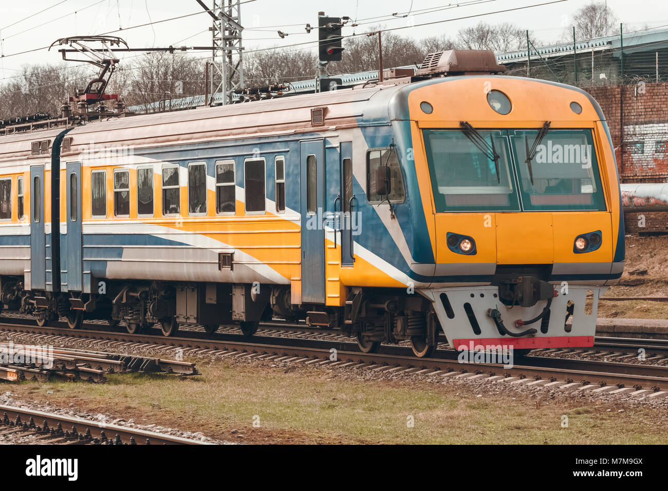 Yellow modern passenger electric train moving at the old terminal Stock ...