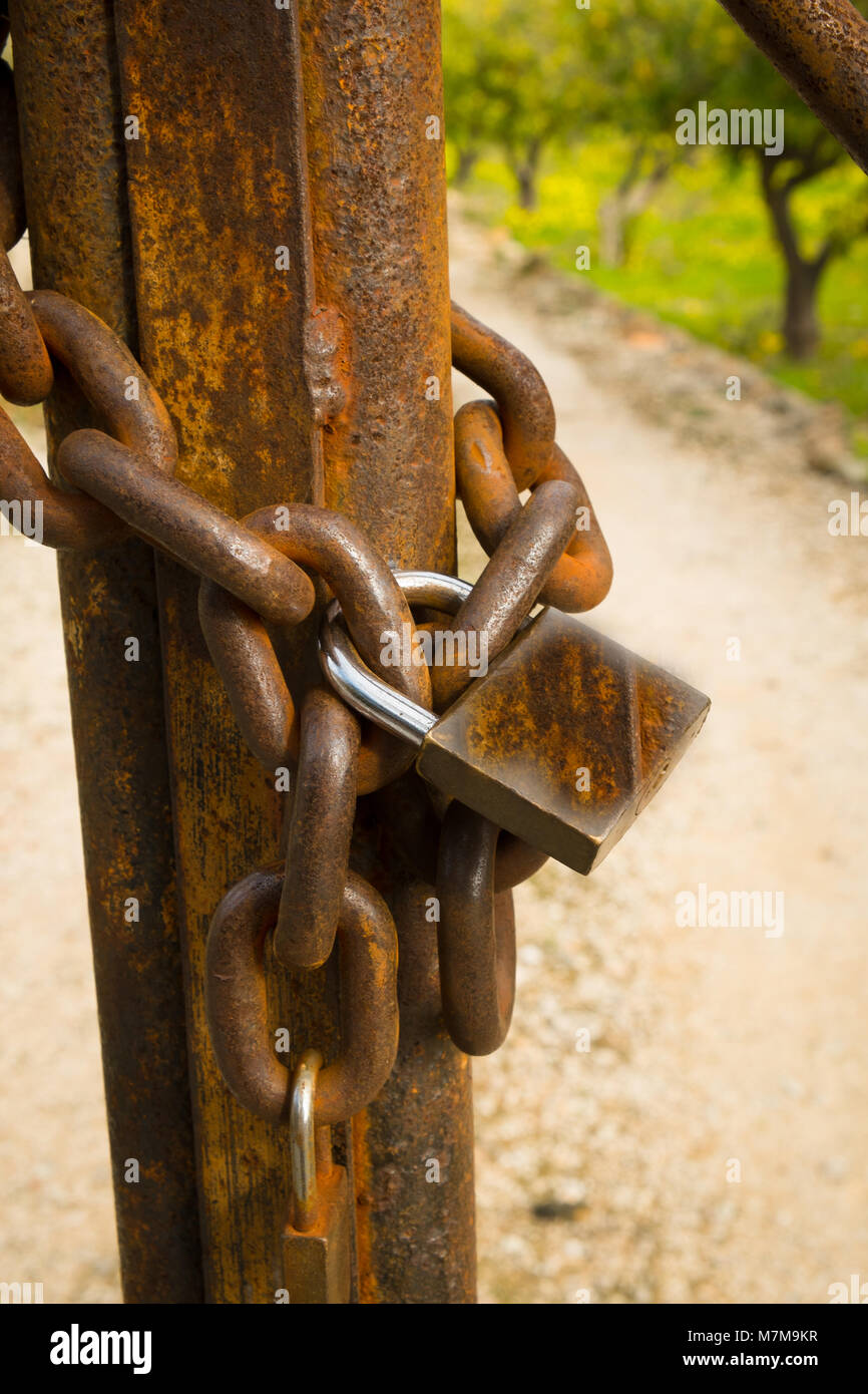 Old padlock and chain securing a gate Stock Photo - Alamy