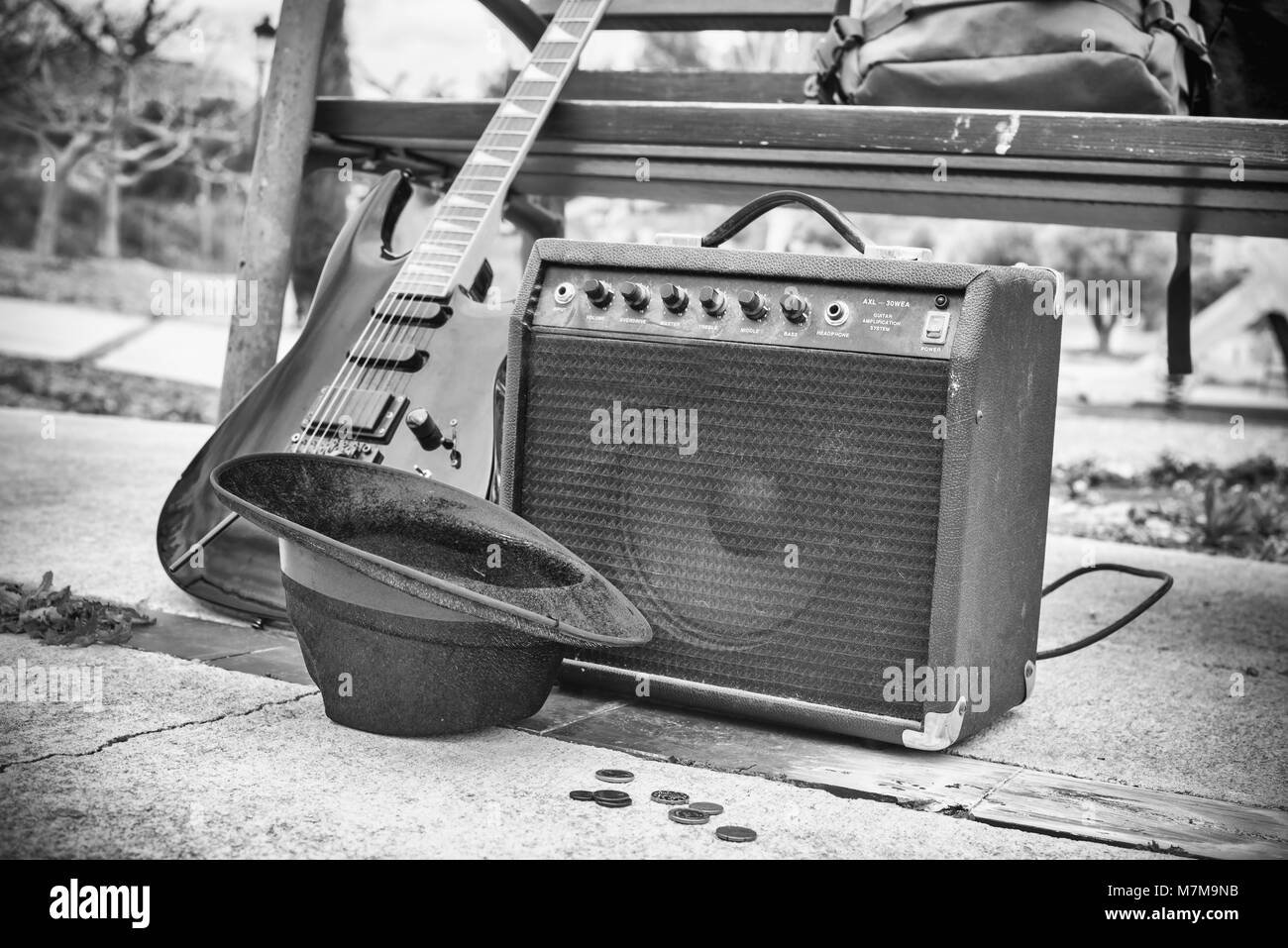 Old guitar and amplifier next to a park bench, a street music concept ...
