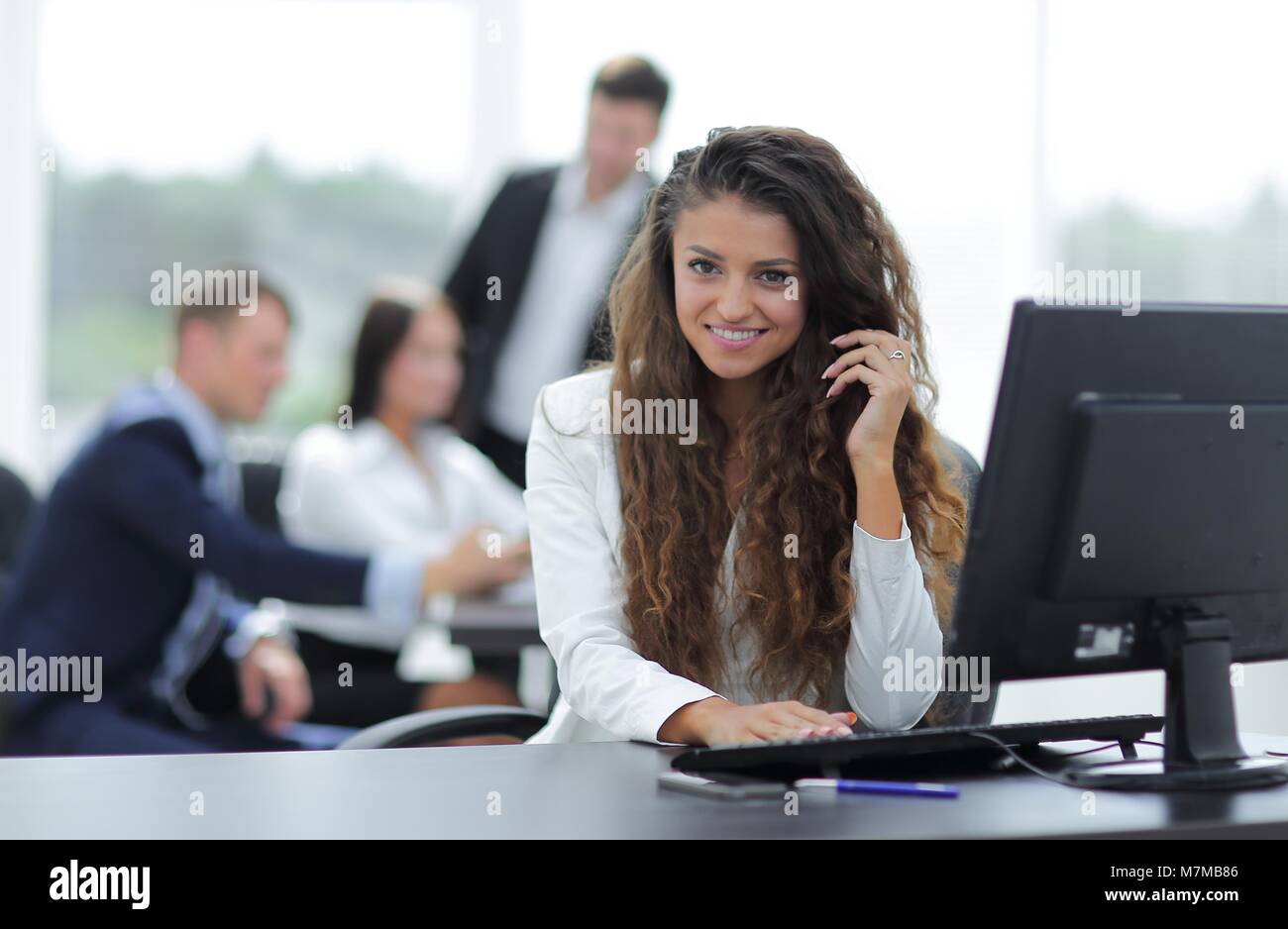 Manager woman sitting behind a Desk Stock Photo - Alamy