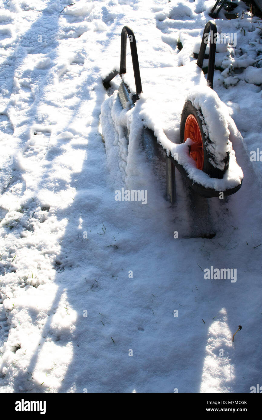 Gardener's time off - wheelbarrow covered in snow Stock Photo - Alamy