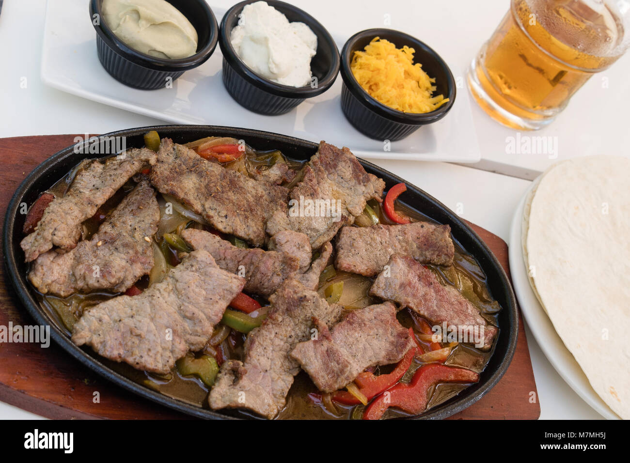Delicious slices of roasted beef meat with red peppers served with ...